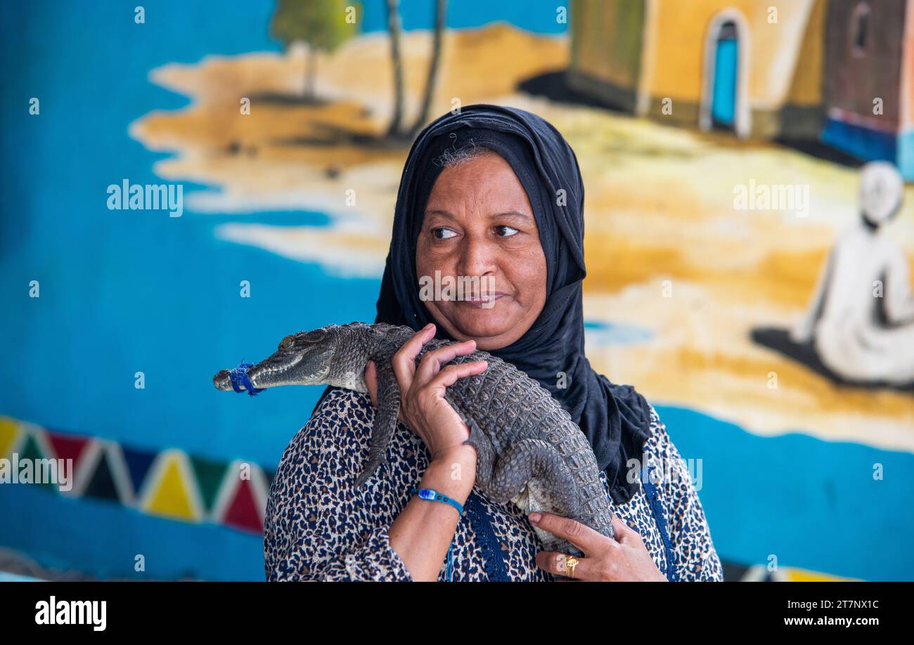 Nubian woman with a young Nile Crocodile, the Nubian tribe have a ...