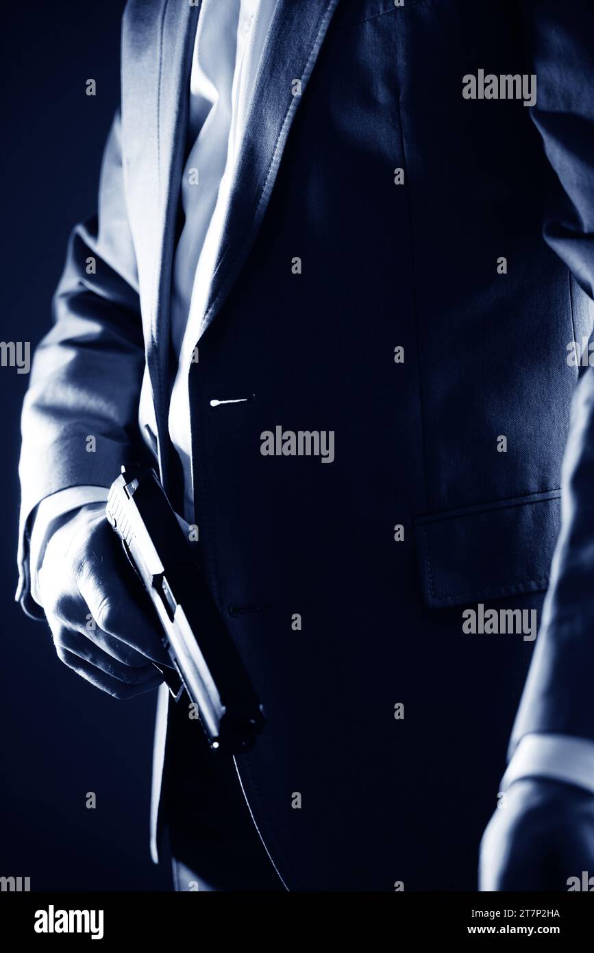 Retro secret agent with pistol revolver gun in hand in vintage crime ...