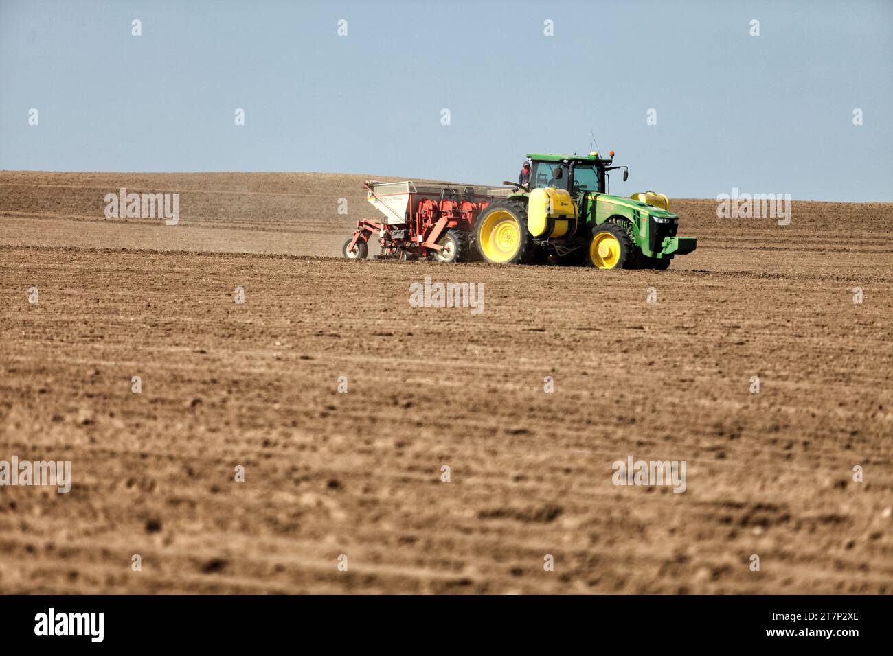 Two tractors with planting implements, work in the fertile farm fields ...
