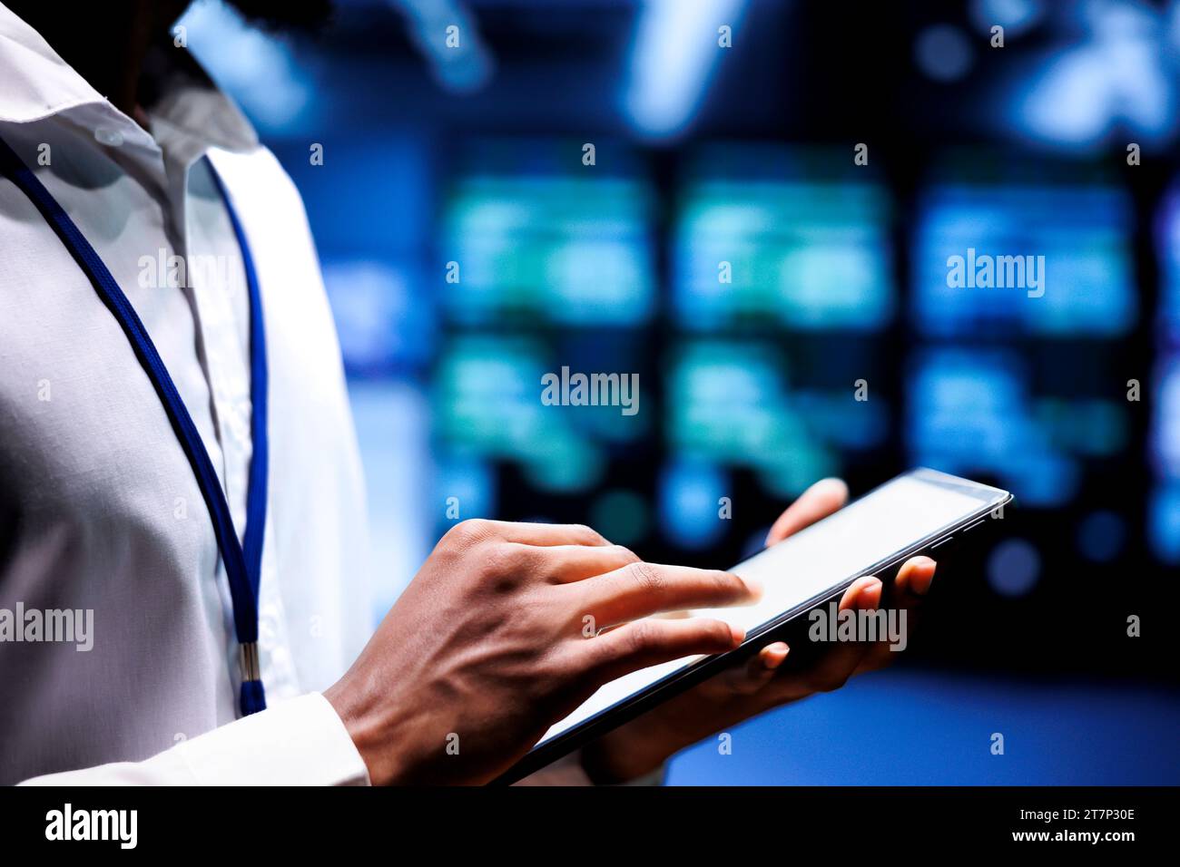 Specialist using mock up tablet to check server rigs doing intense computations. Technician ...