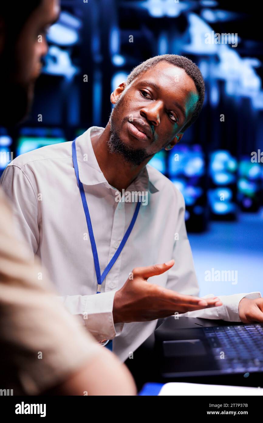 African american expert and colleague dealing with server room system ...