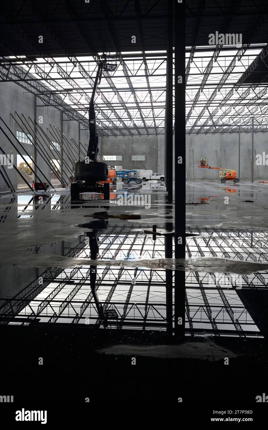 A welder welding steel roof trusses during the construction of a ...