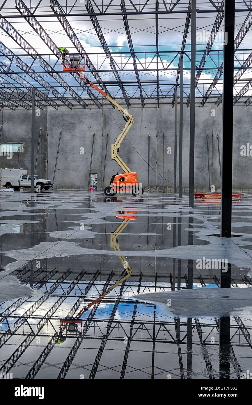 A welder welding steel roof trusses during the construction of a ...