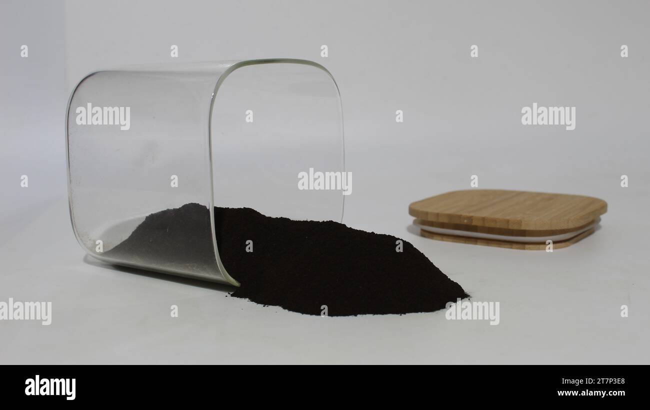 Black walnut hull powder spilled from a jar Stock Photo - Alamy