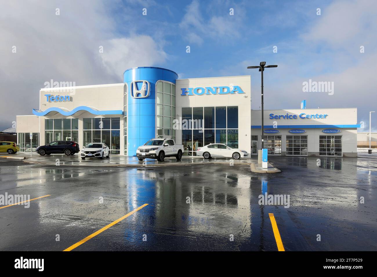 A new modern Honda car dealership building with cars on the lot, and a ...
