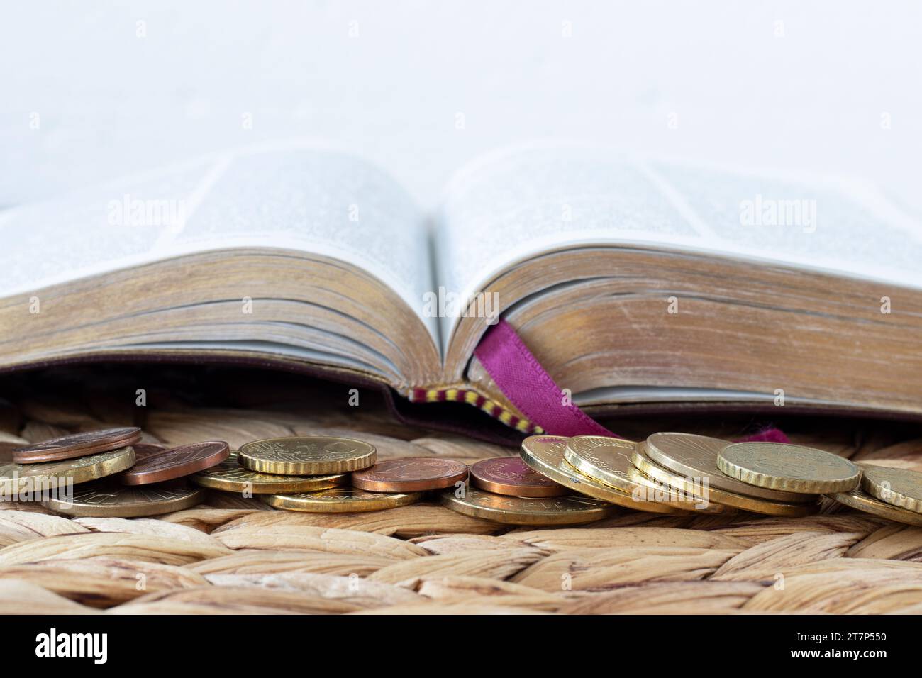 Coins money in front of open holy bible with white background. Close-up ...