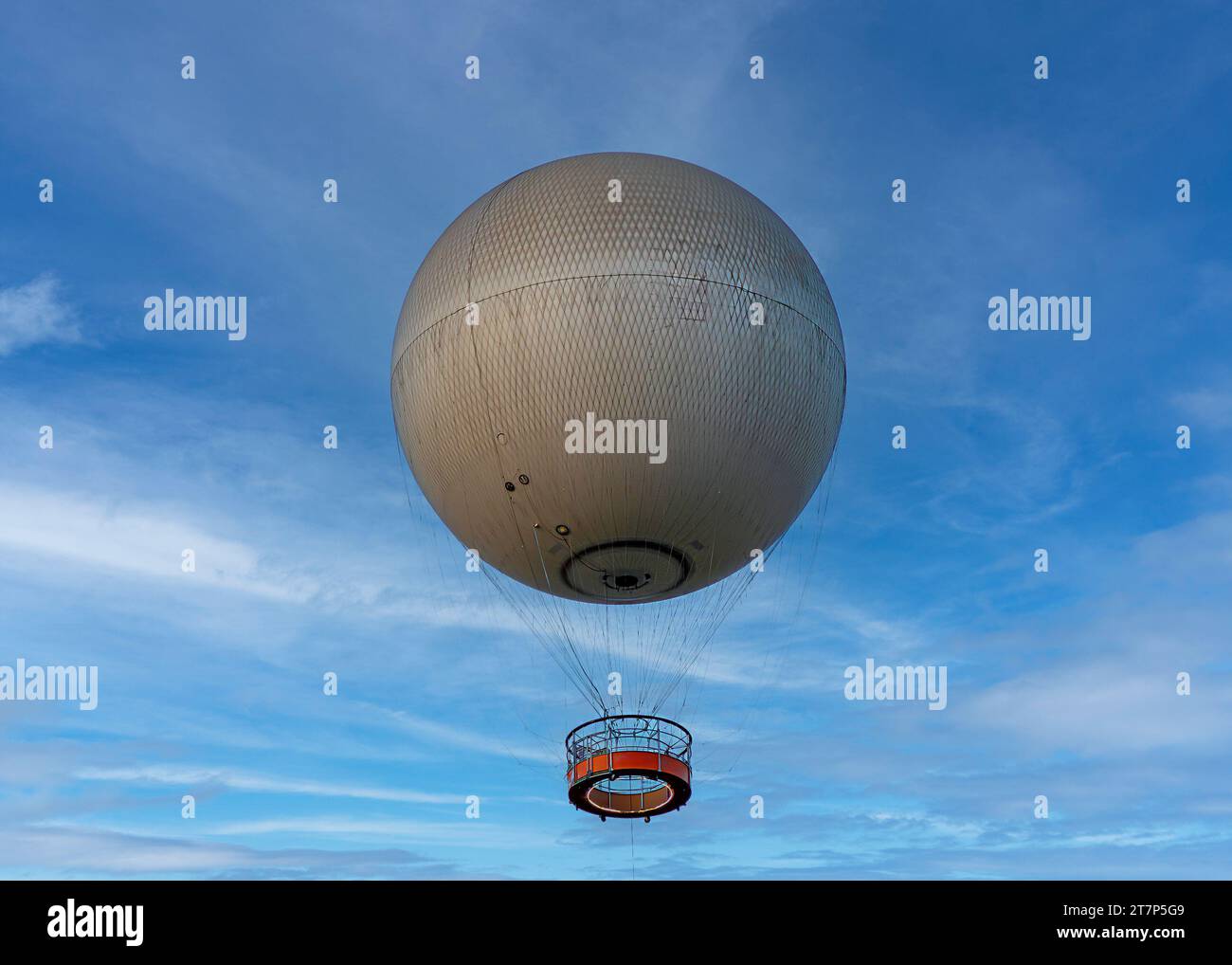 Helium balloon floating in the sky tied to a floor tethered to a ground ...