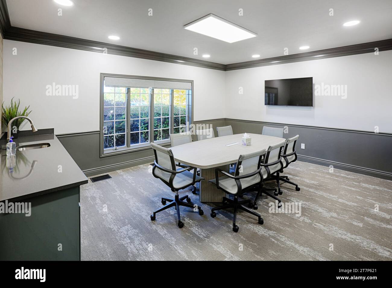 An interior view of a small corporate conference room with furniture ...