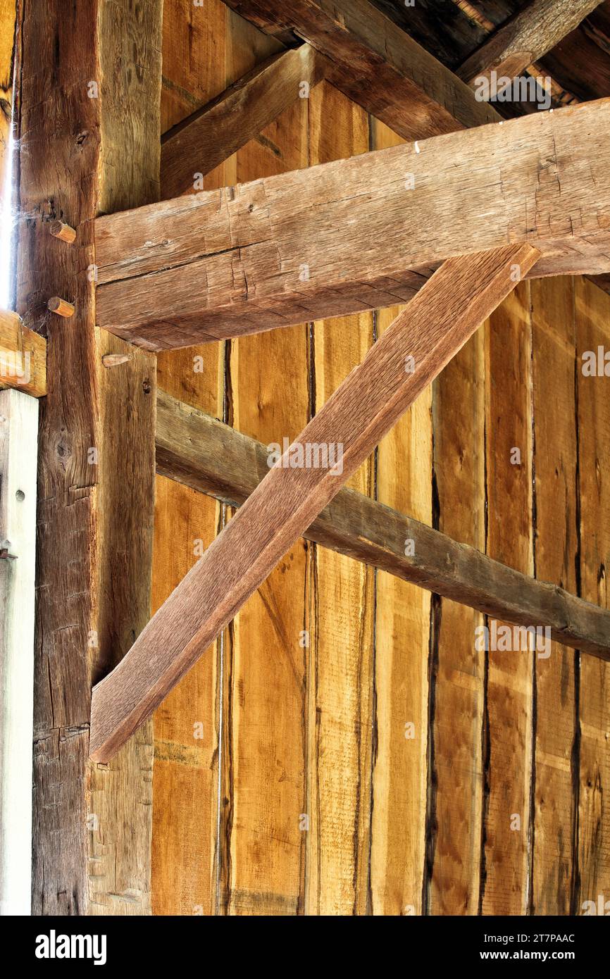 Holes are drilled in to wood beams, and wood pegs, hammered,secure ...