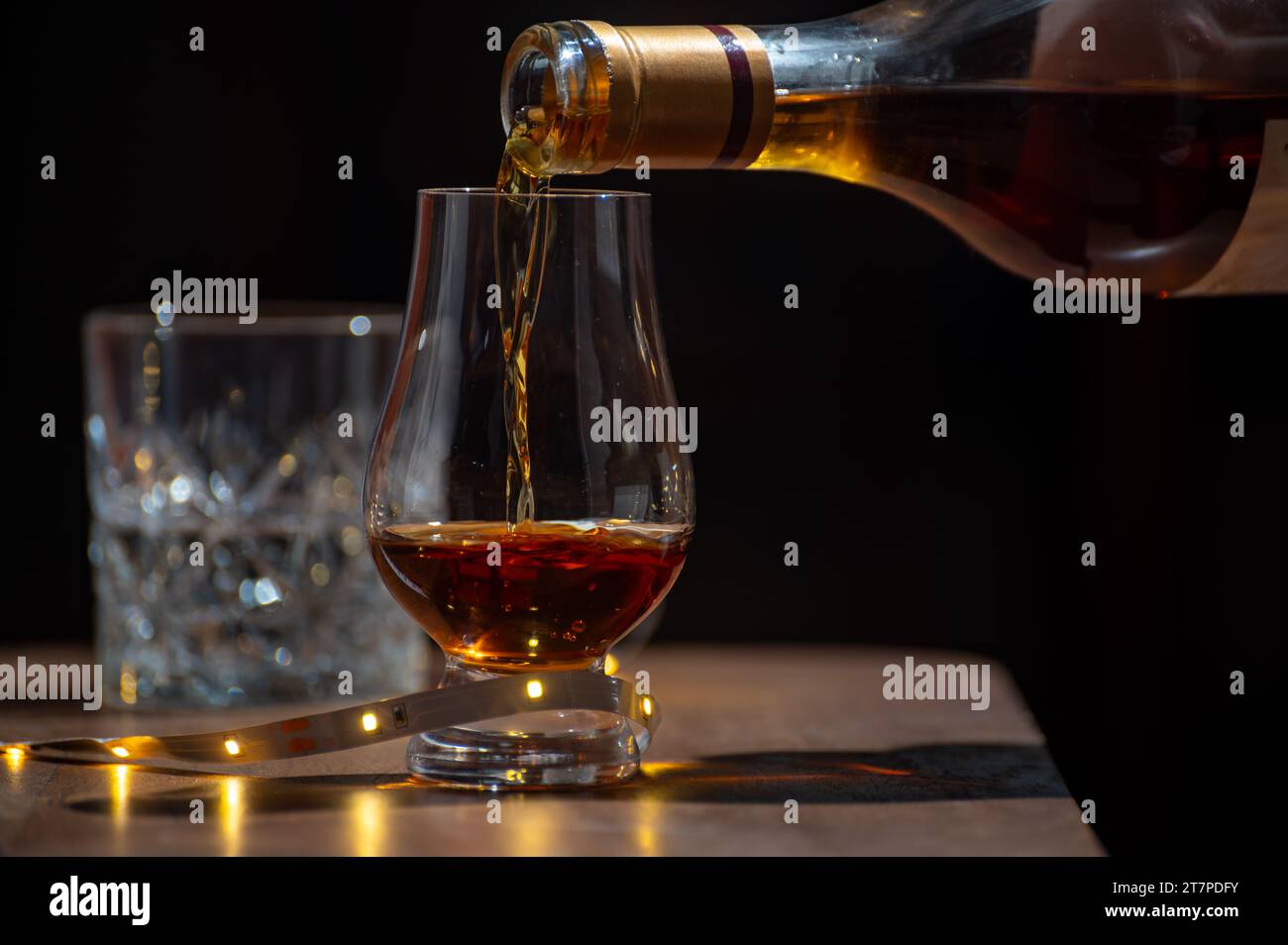Pouring of whisky, glasses of single malt and blended scotch whisky ...