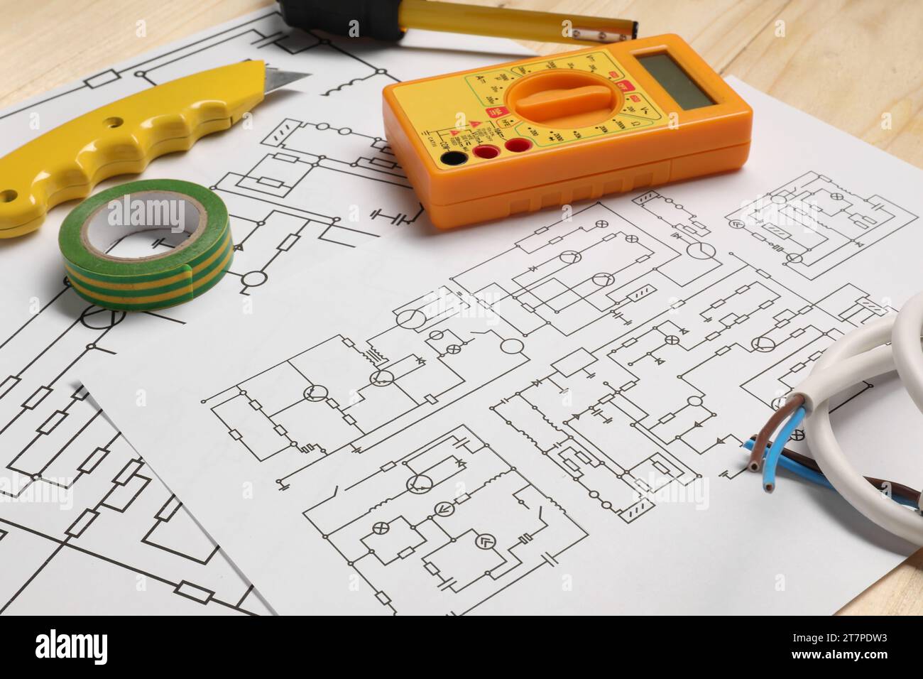 Wiring diagrams, wires and digital multimeter on wooden table, closeup ...