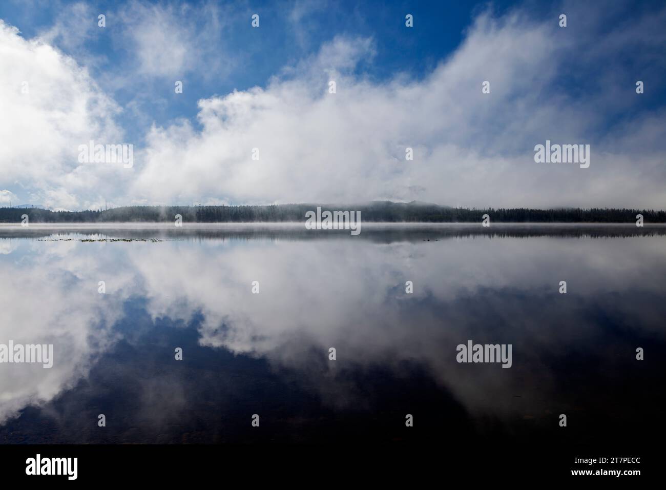 Clouds and fog reflect in the waters of Riddle Lake near Grant Village ...