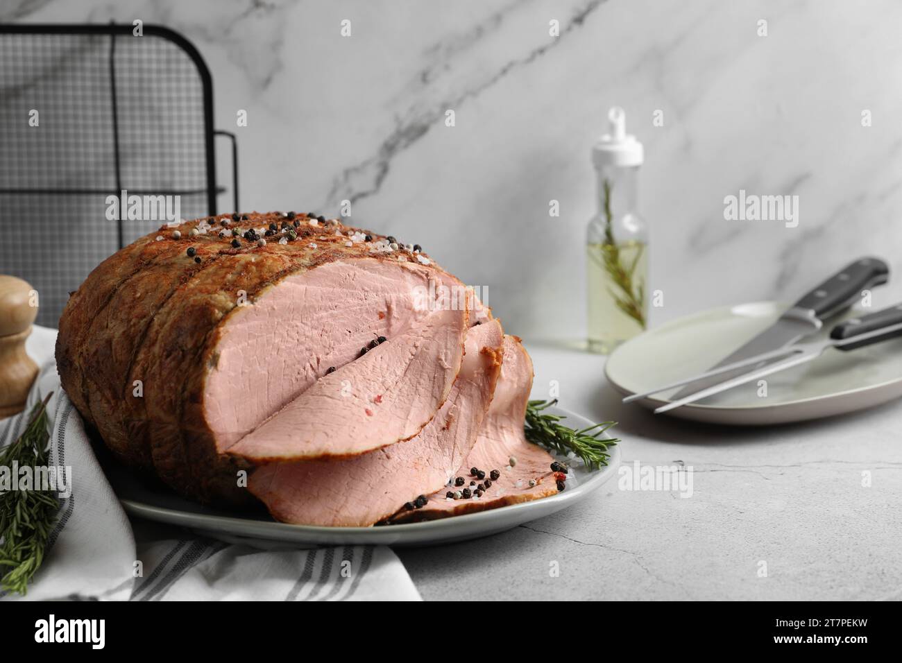 Delicious baked ham and rosemary on light grey table. Space for text ...