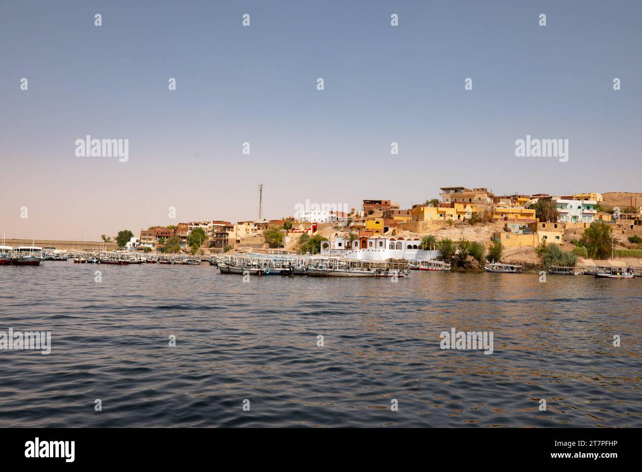 Colorful houses and tourist boats along the banks of the Nile River as ...