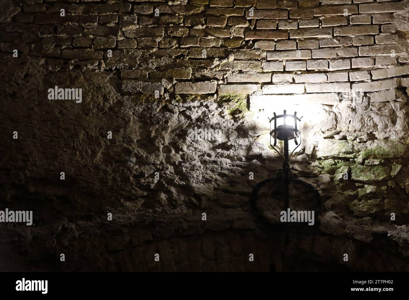 Lighted medieval castle torch hanging on a stone wall, vintage objects ...