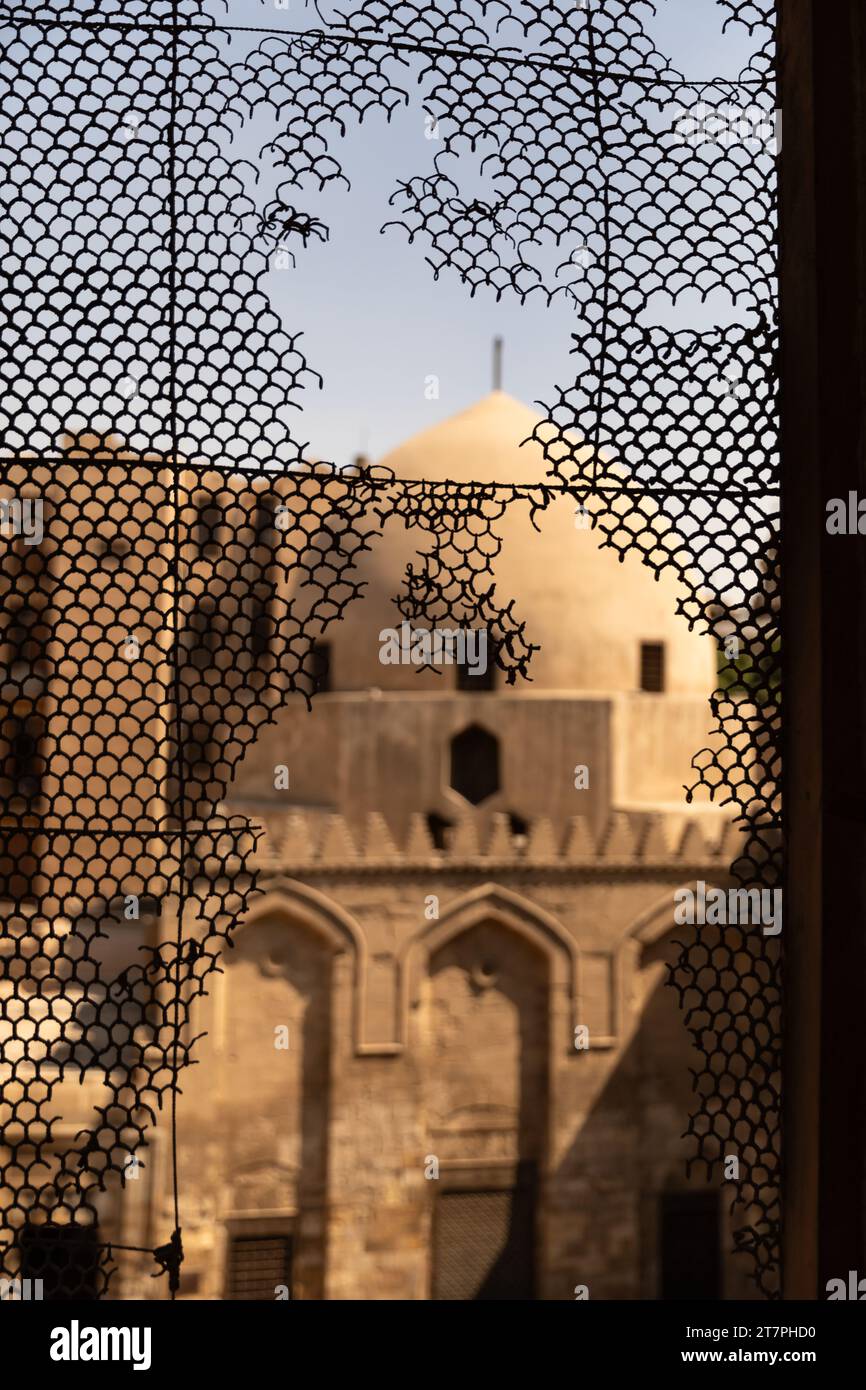 Historic sandstone mosque viewed through torn wire fence Stock Photo ...