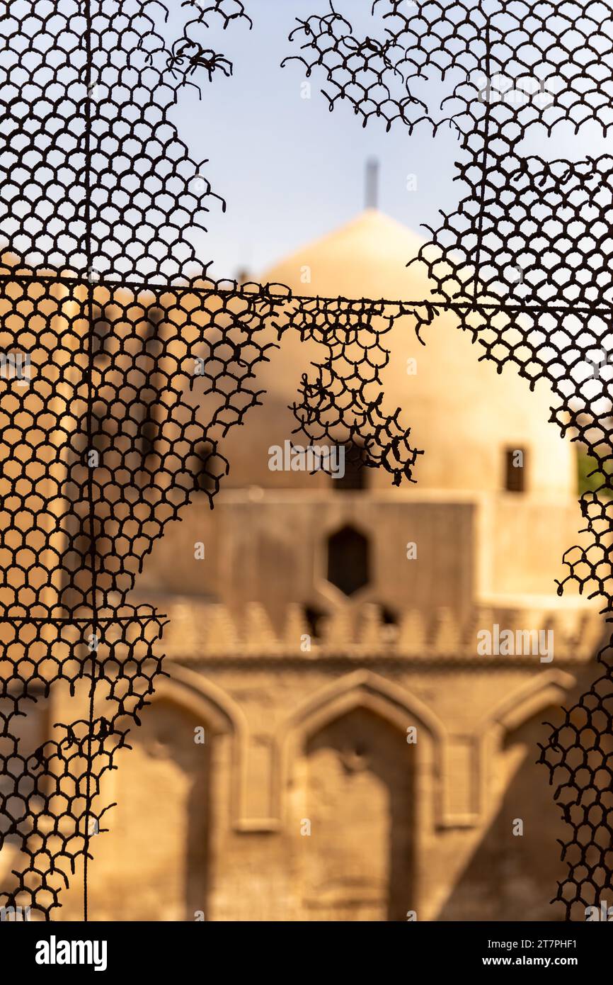 Historic sandstone mosque viewed through torn wire fence Stock Photo ...