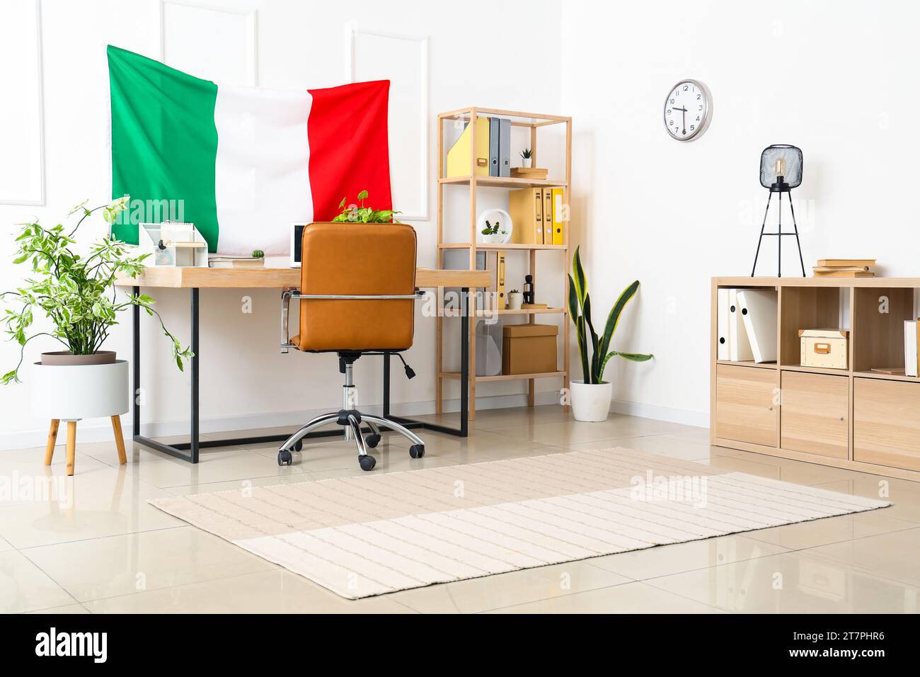 Modern workplace with laptop, stationery and hanging Italian flag in ...