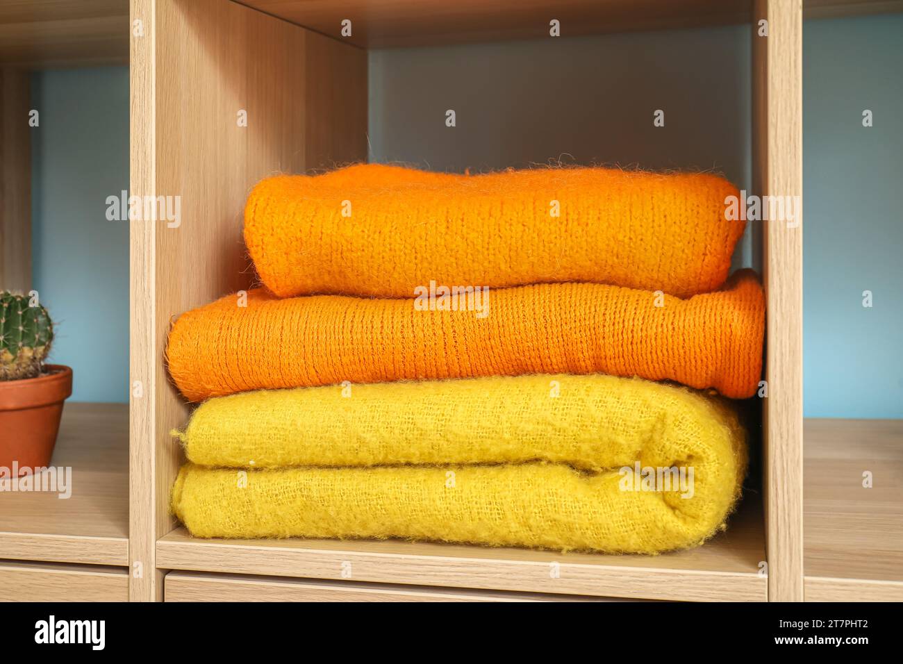 Stack of warm clothes in wardrobe, closeup Stock Photo - Alamy