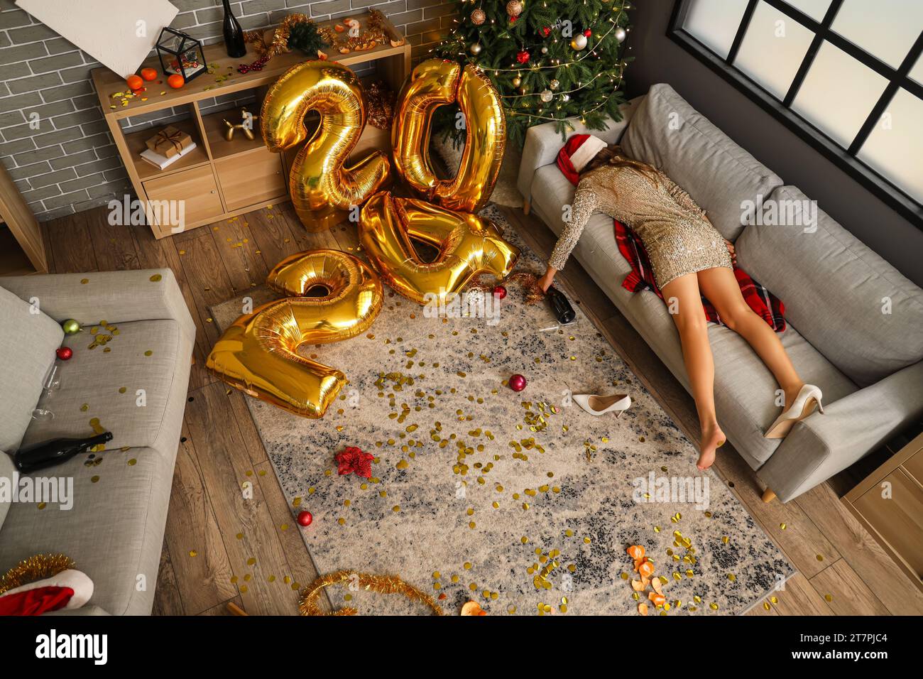 Drunk woman lying on sofa in messy living room after New Year party ...