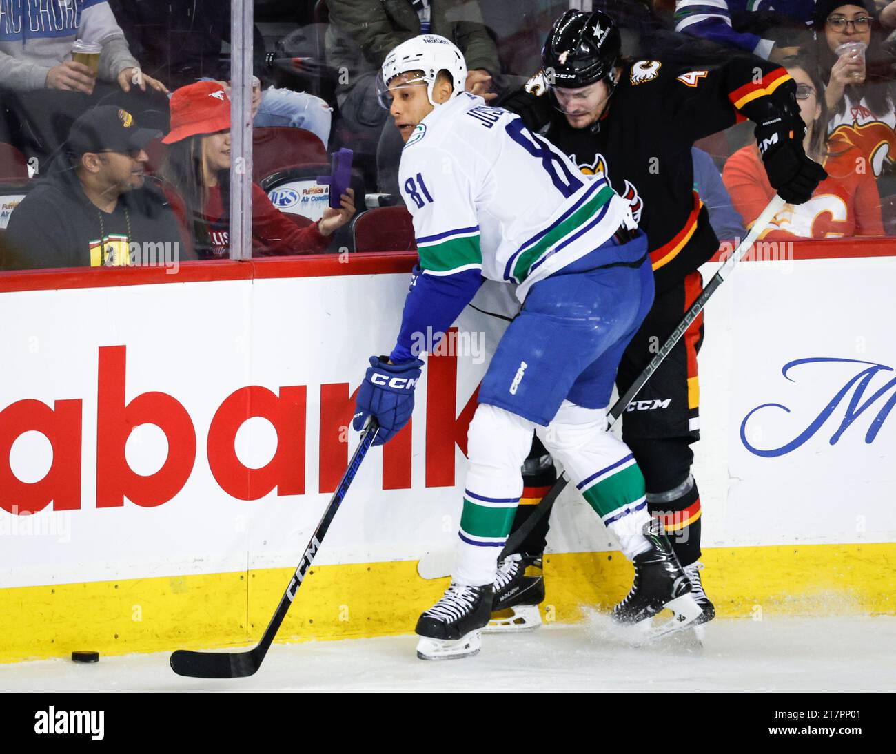 Vancouver Canucks forward Dakota Joshua, left, checks Calgary Flames ...