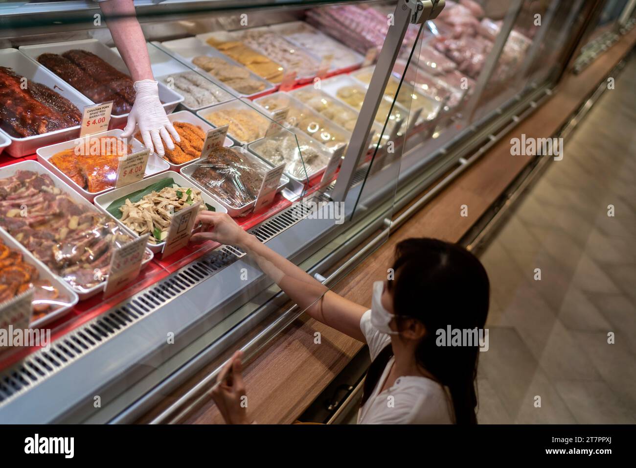 Workers decorate a display case at Huber's Butchery in Singapore ...