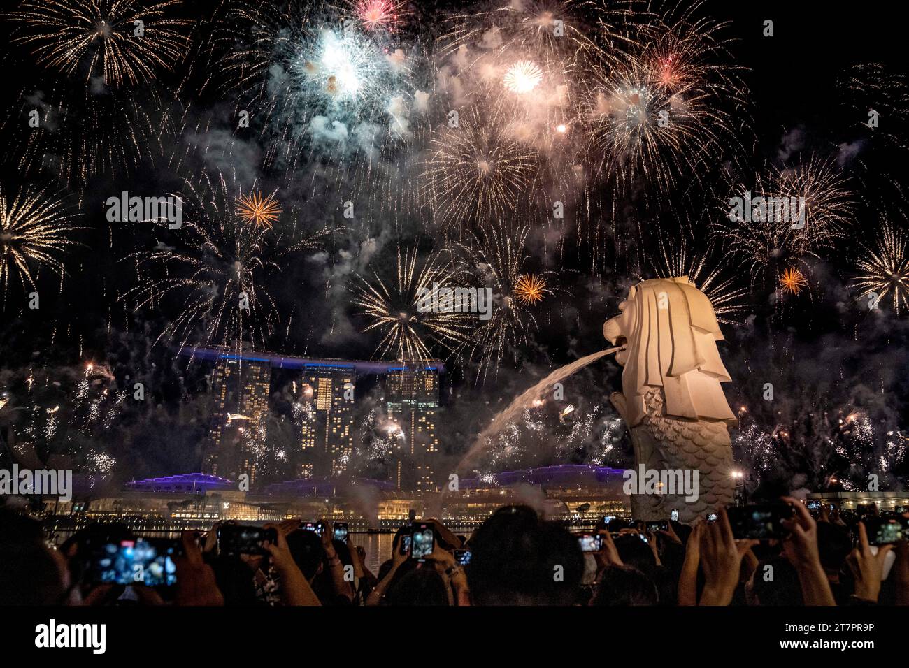 Fireworks go off over the Merlion, right, and the Marina Bay Sands in ...