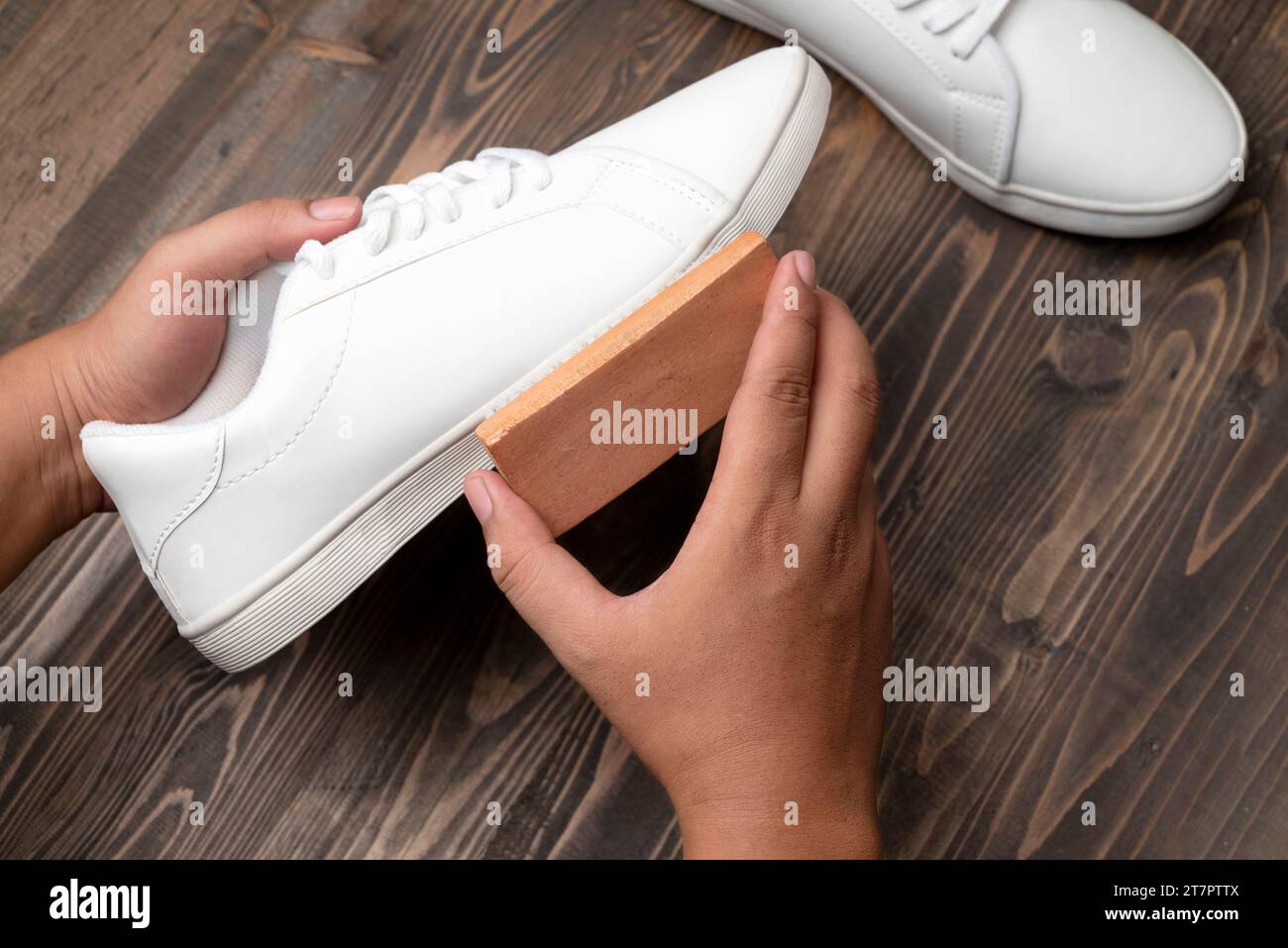 Human hand cleaning white sneakers with a brush. Shoe care concept ...