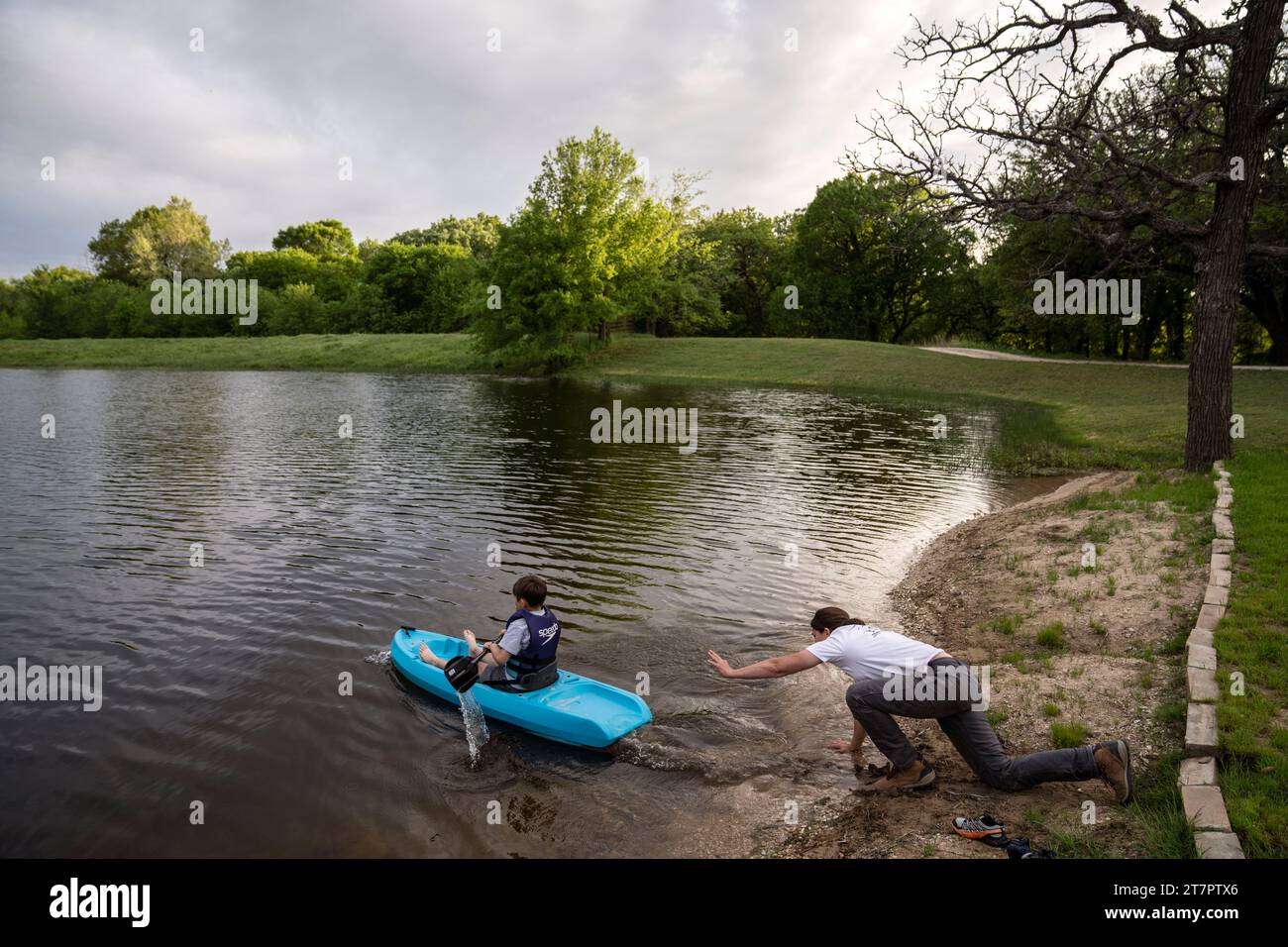Rancher Meredith Ellis, right, pushes her son, GC, 6, in his kayak on ...