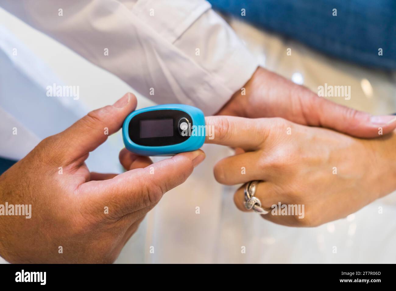 Doctor is putting a pulse oximeter in his patient's hand for measuring ...