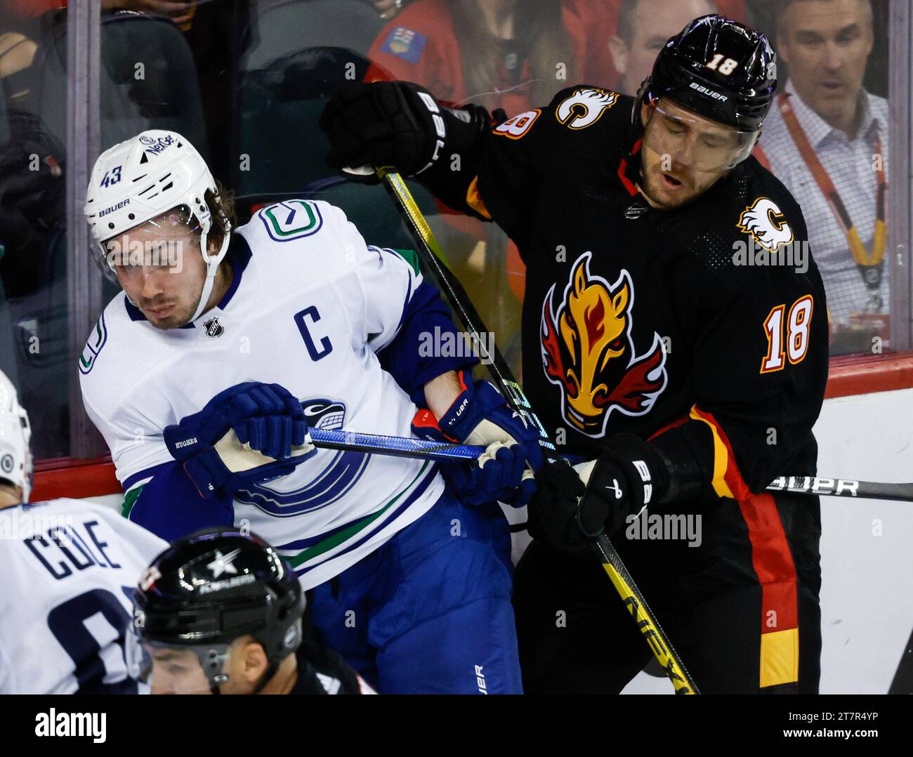 Vancouver Canucks defenseman Quinn Hughes, left, is checked by Calgary ...