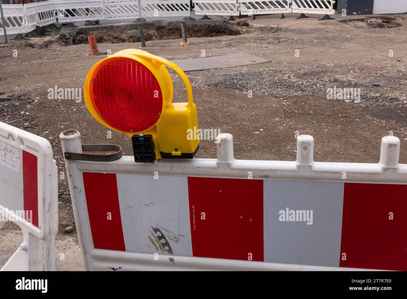 Close-up of a red warning light with street barriers at a construction ...