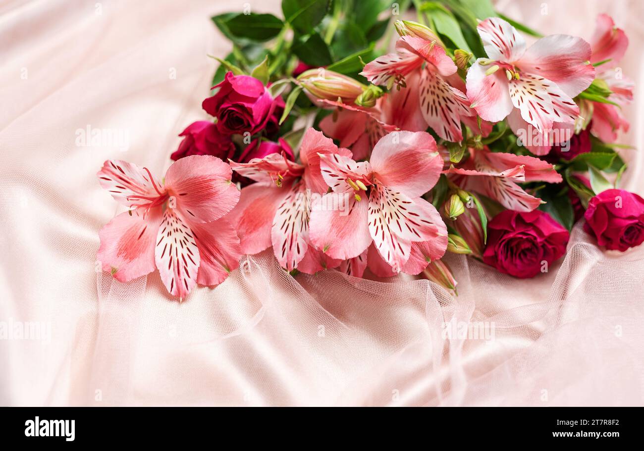 Beautiful pink alstroemeria and roses flowers on soft pink silk ...