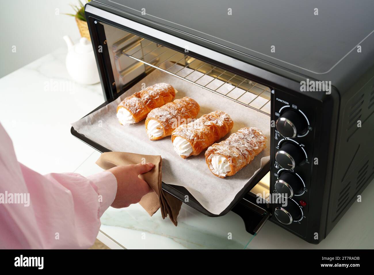 Woman's hands taking fresh bakery out of mini oven Stock Photo - Alamy