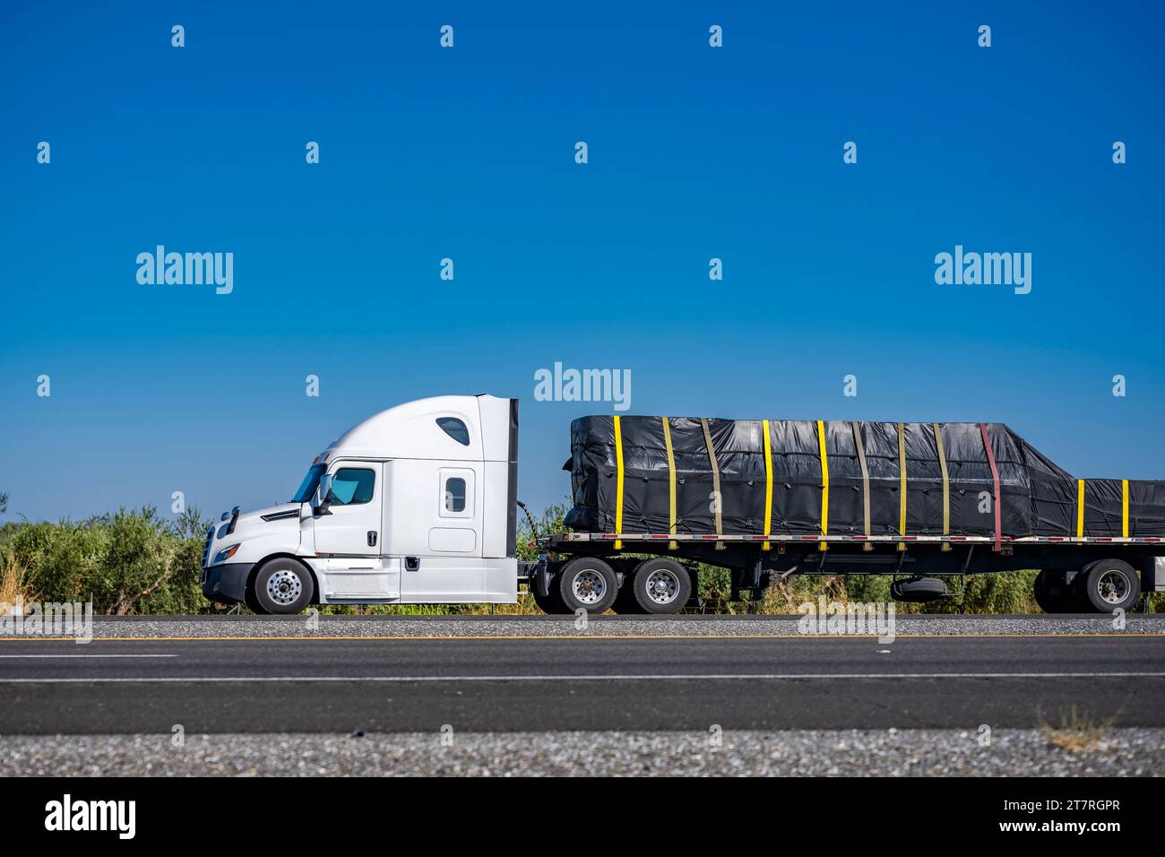 White high cab profile carrier big rig semi truck transporting cargo on ...