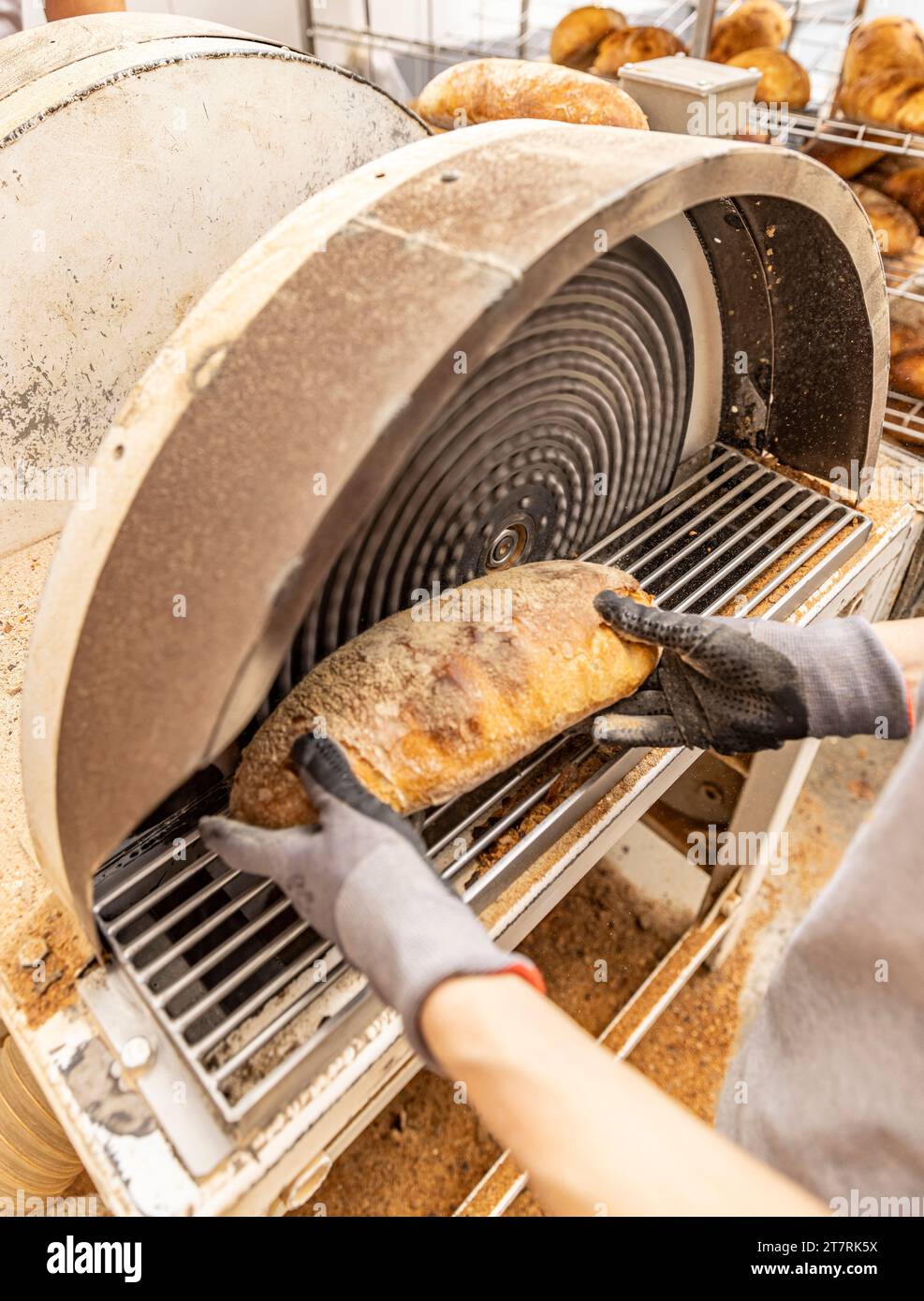 Unrecognizable worker grate bread crust in factory preparing for sell ...