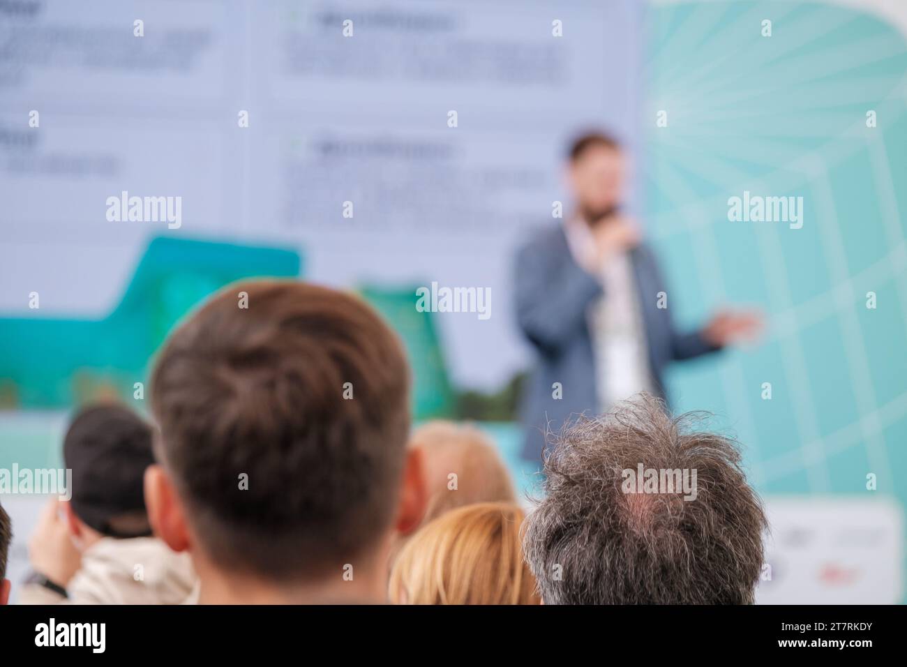Businessman explaining diagram on stage to colleagues during ...