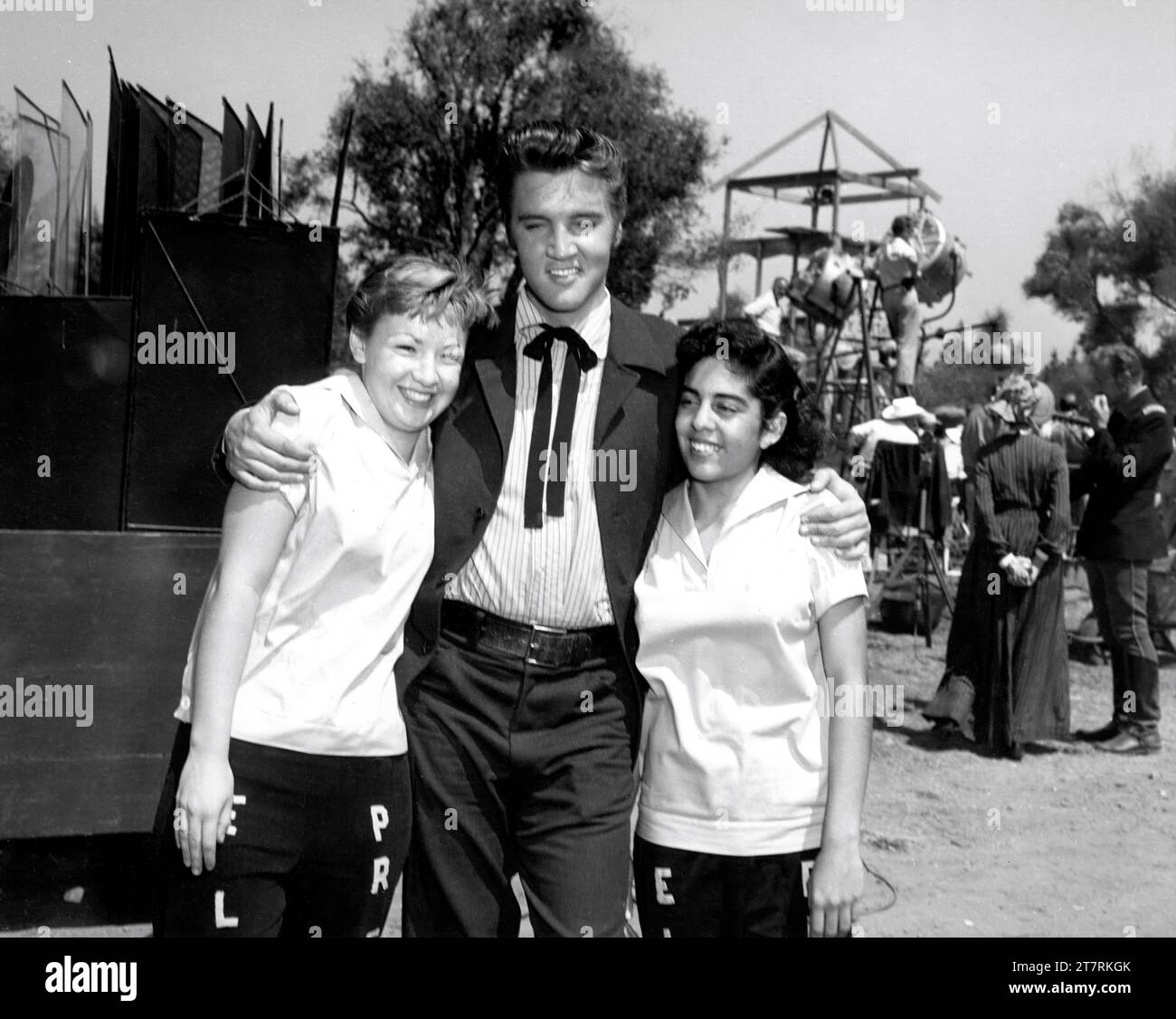 ELVIS PRESLEY poses with two young female fans on set candid during ...