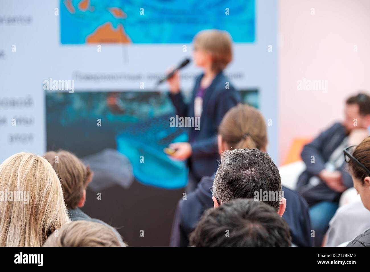 Businessman explaining diagram on stage to colleagues during ...