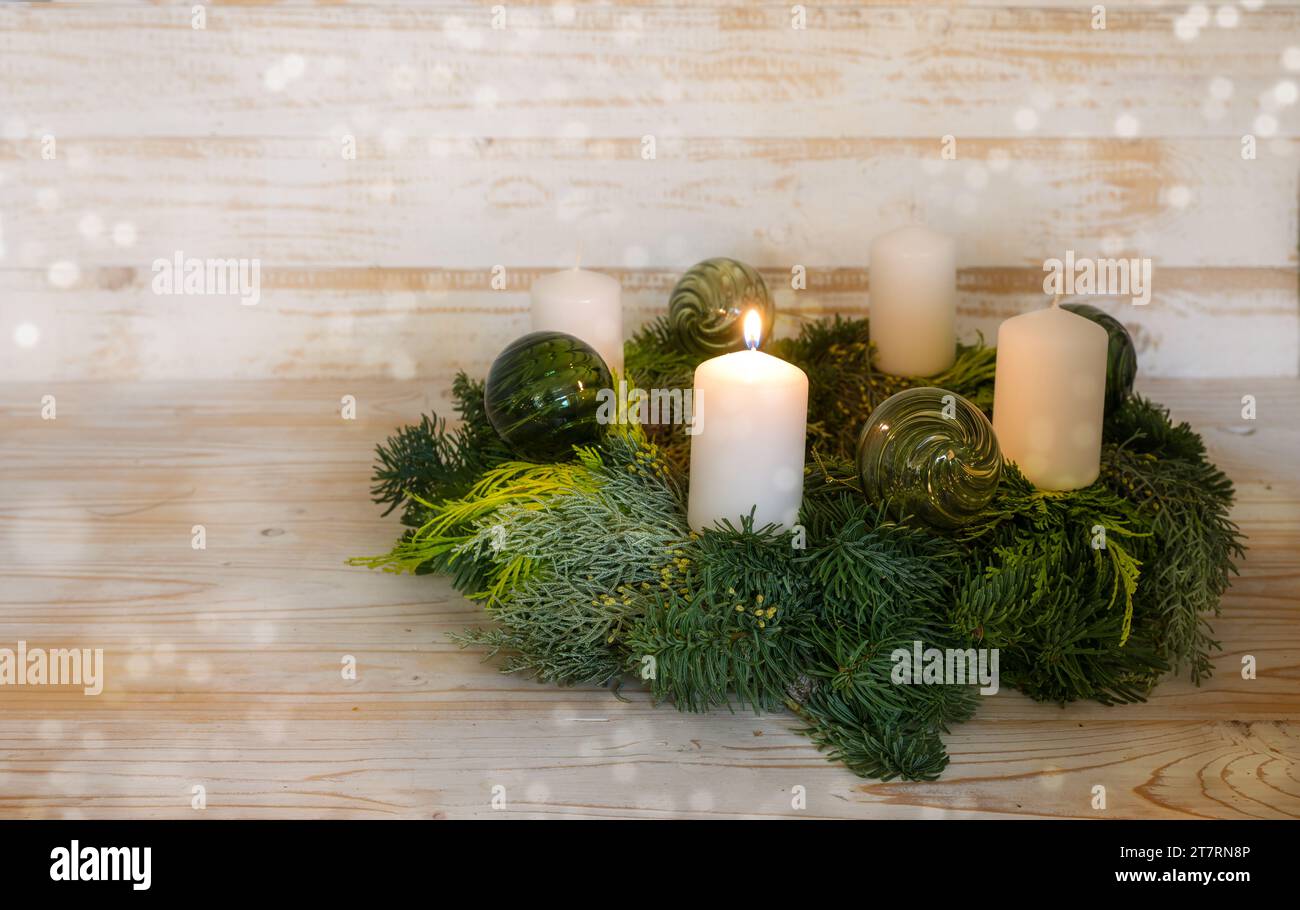 First advent, natural advent wreath with white candles, one is lit ...