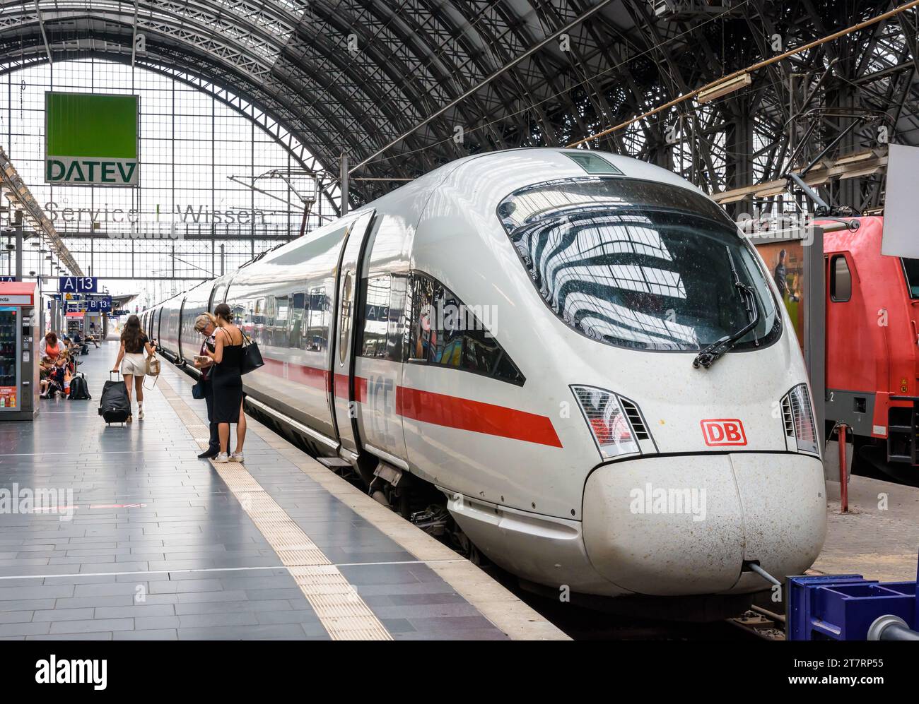 An inspector checks the e-ticket of a young woman in front of an ICE ...