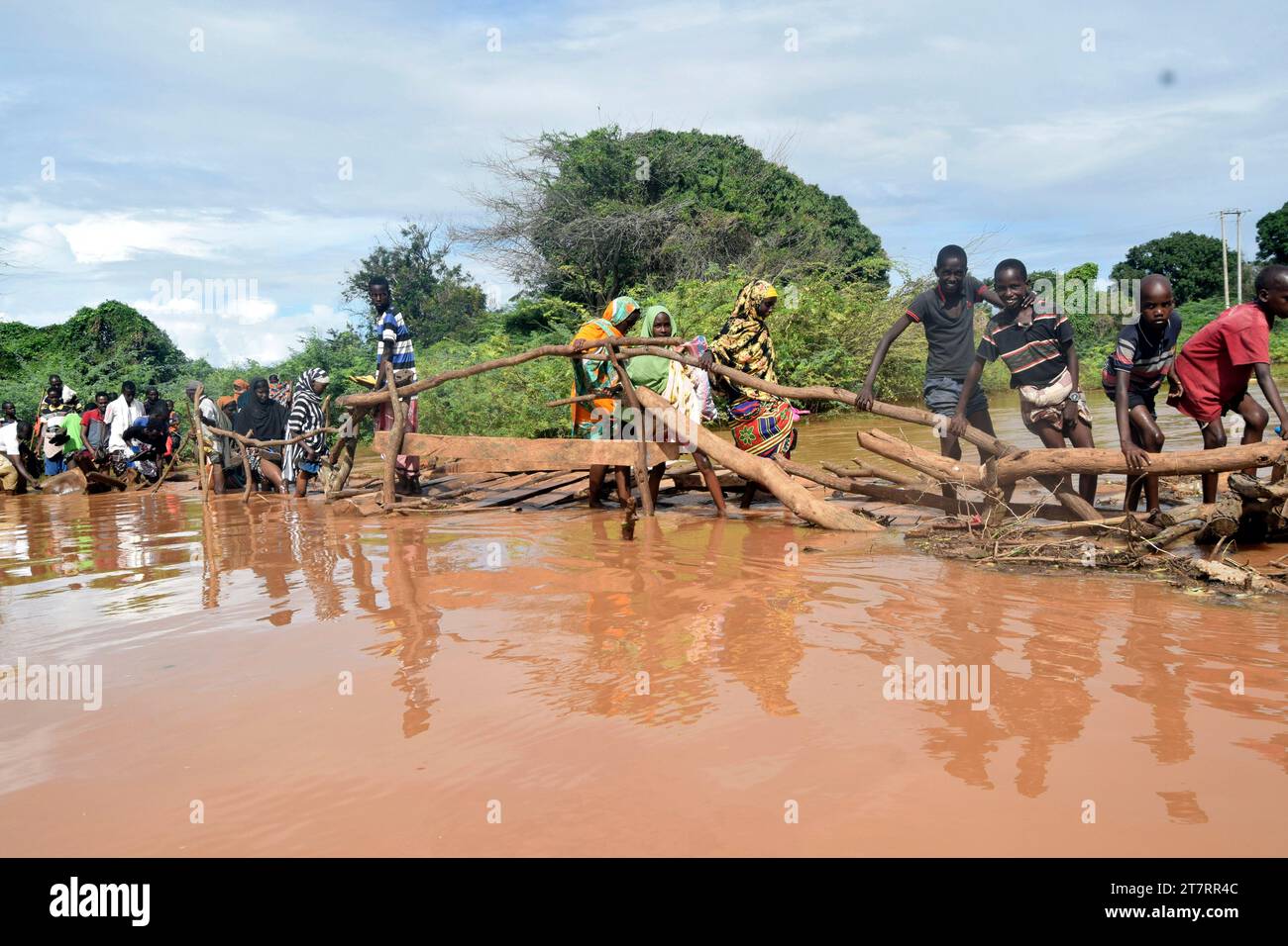 Residents of Chamwana Muma village walk through flood water after using ...