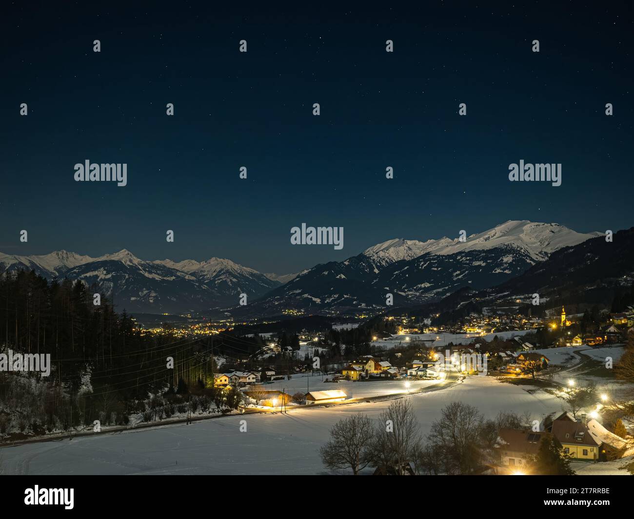 Night landscape with starry sky in the Alps, with street lights and ...