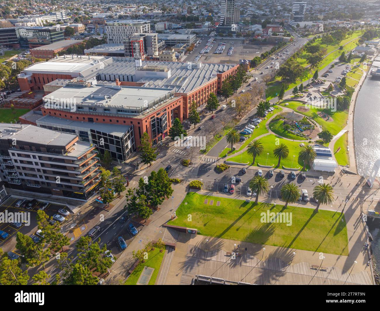 Aerial view of green parkland between the sea and a city waterfront at ...
