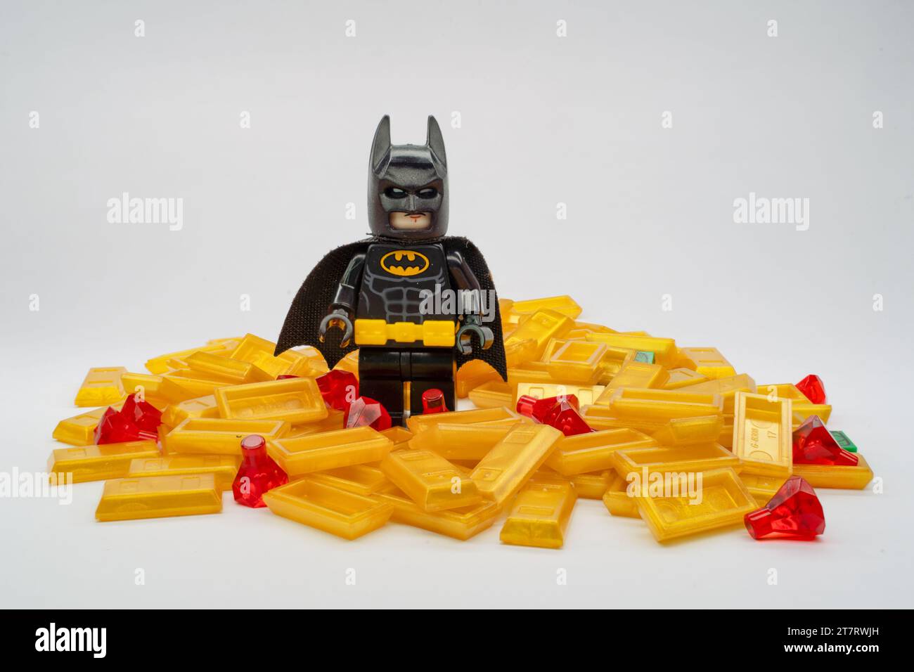 A LEGO Batman Minifigure in front of yellow LEGO pieces resembling gold ...