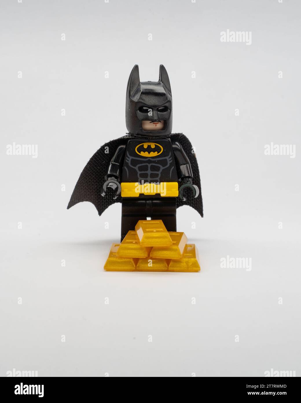 A LEGO Batman Minifigure in front of yellow LEGO pieces resembling gold ...