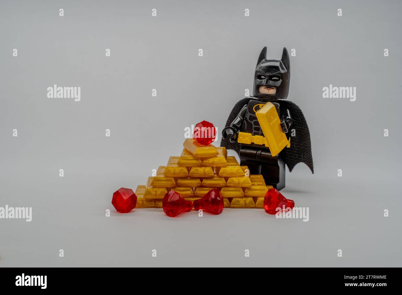 A LEGO Batman Minifigure in front of yellow LEGO pieces resembling gold ...