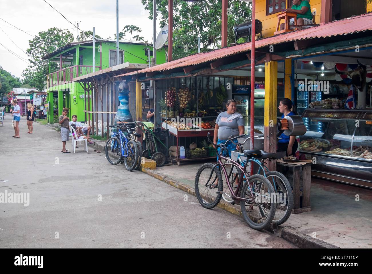 People and shops on a main street in the town of Tortuguero in Costa ...