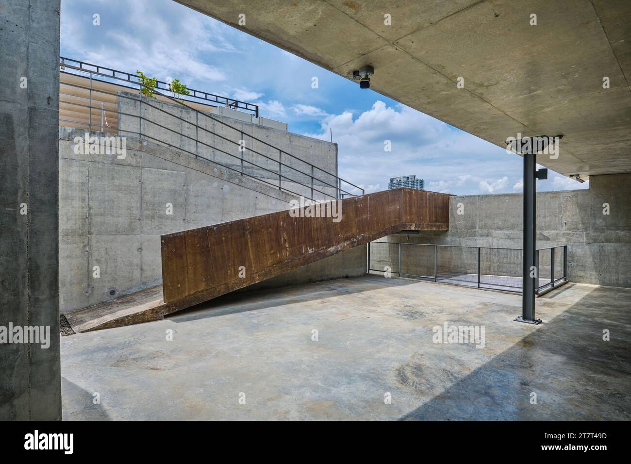 A rusty, steel ramp wall is featured, leading up to the top level where ...