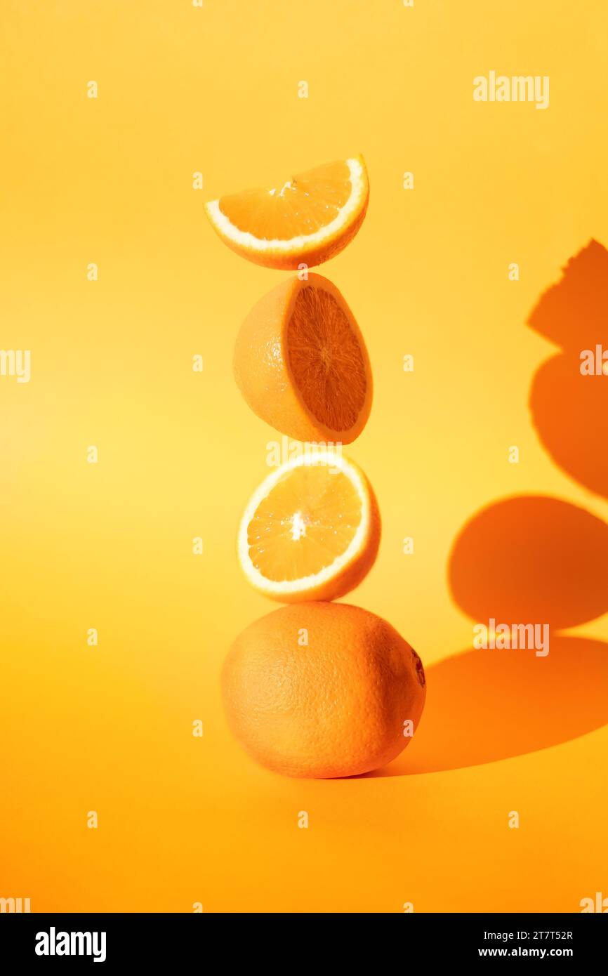 Orange floating in front of orange backdrop Stock Photo - Alamy